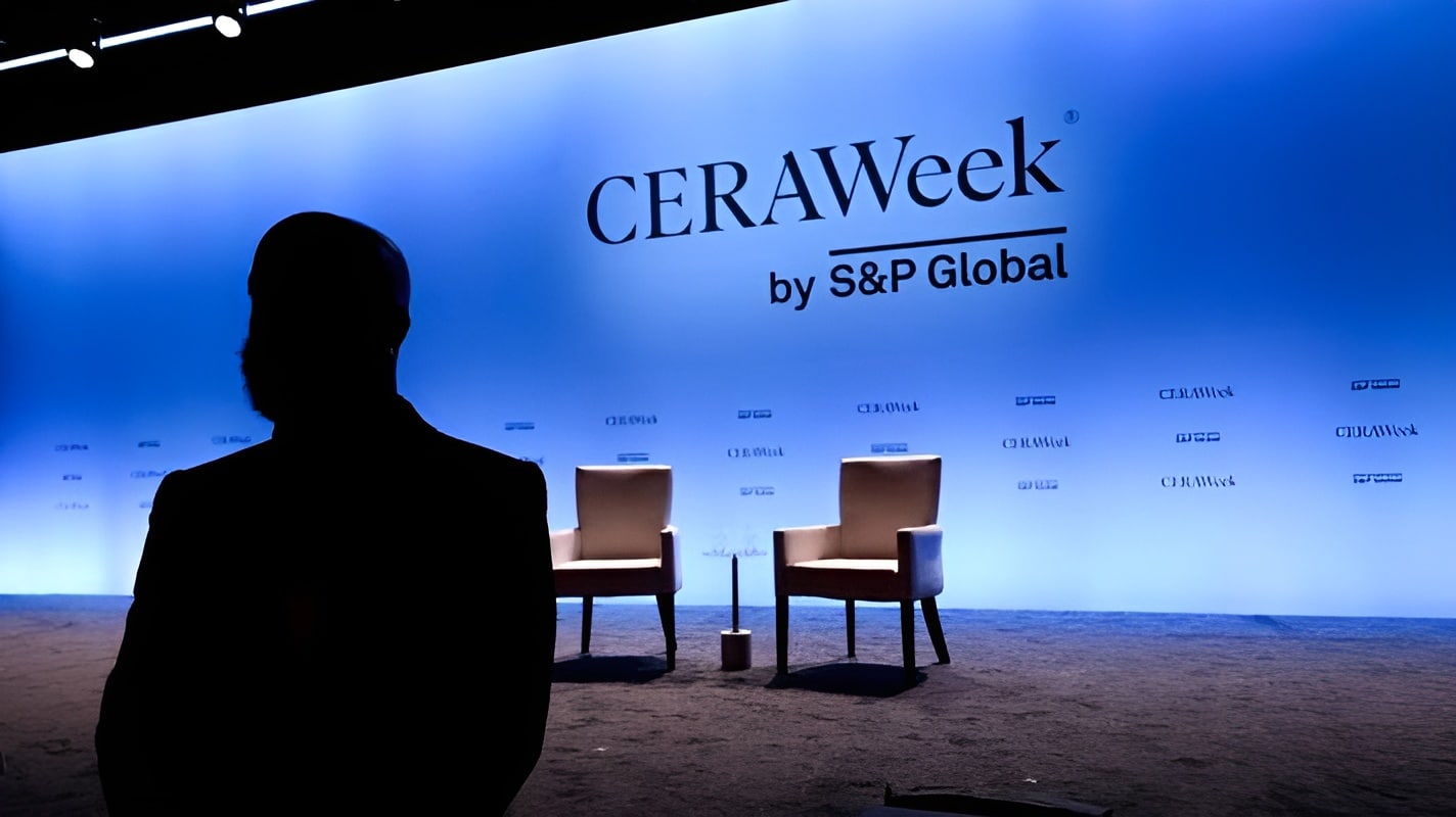 Silhouette of a passerby near the stage at the CERAWeek 2025. Photo: Bloomberg.